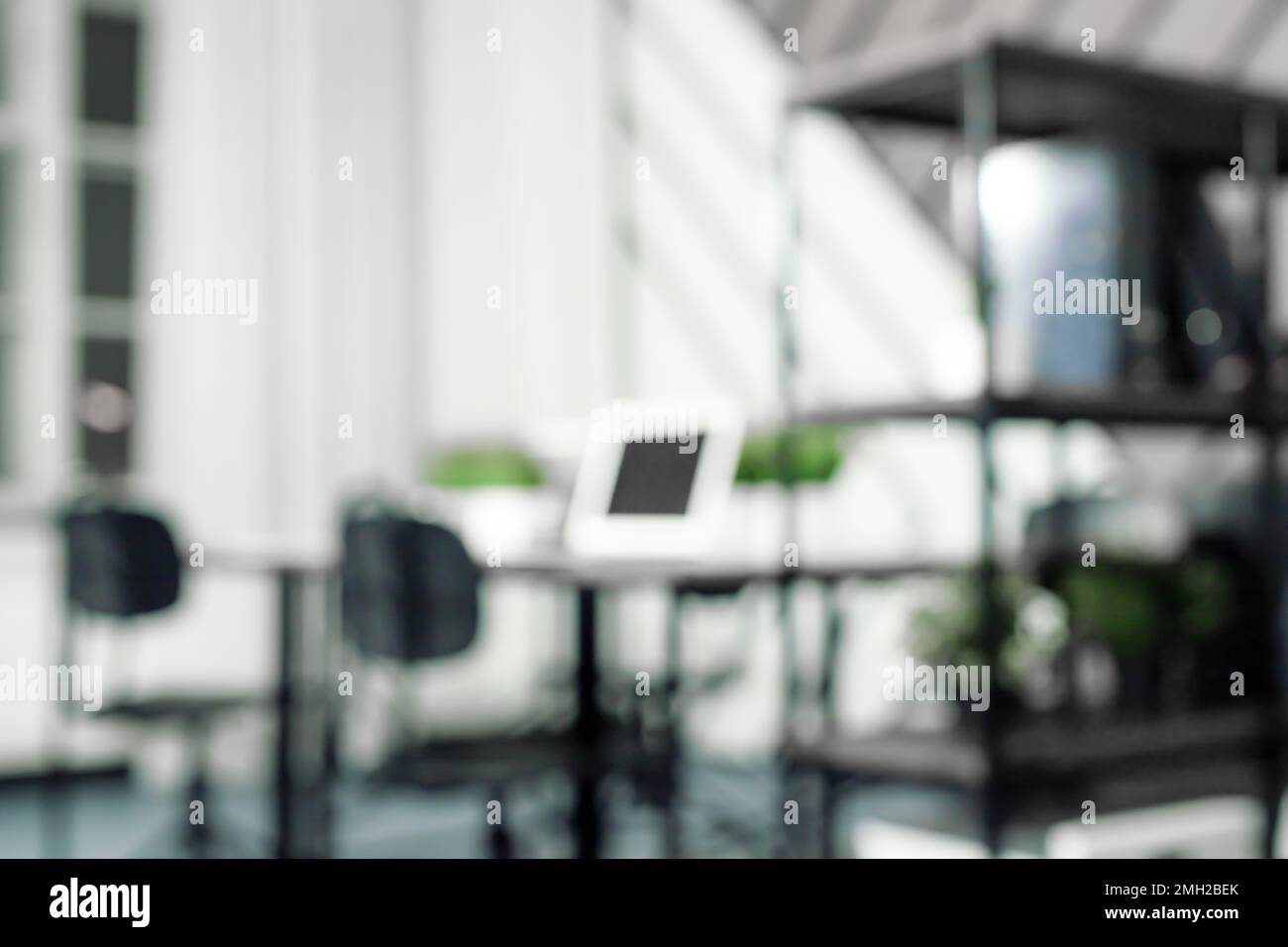 Blurred modern office background with laptops, work desks, chairs ...