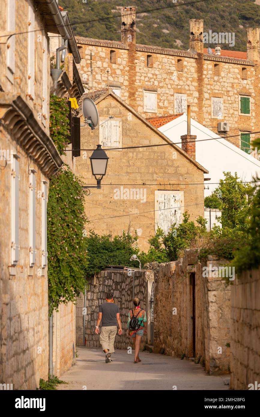 ISLAND OF VIS, CROATIA, EUROPE - Couple walks on narrow street in town ...