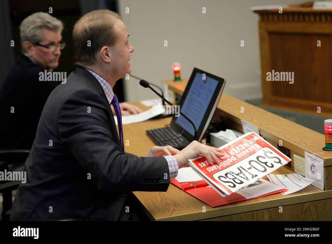 Initiative promoter Tim Eyman, right, holds a sign promoting his $30 ...