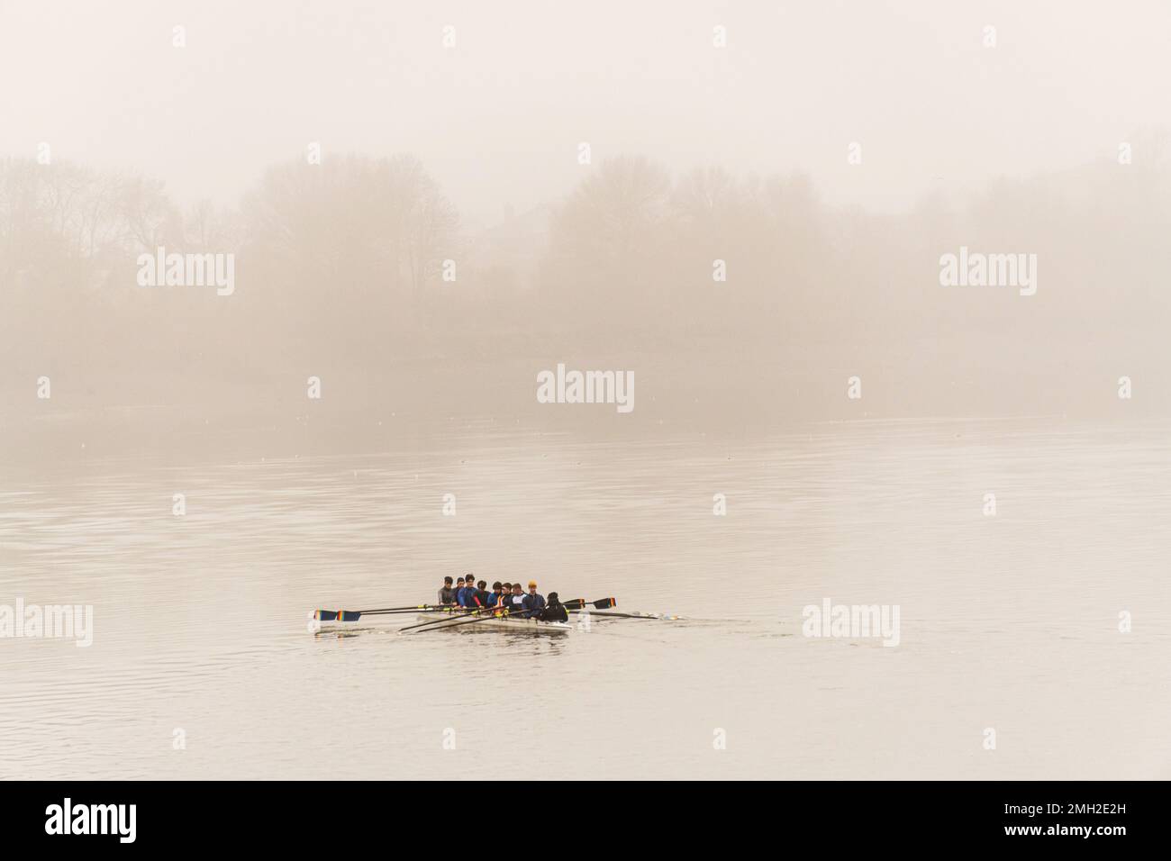 A rowing 8 training on The River Thames from Putney on a misty Morning ...