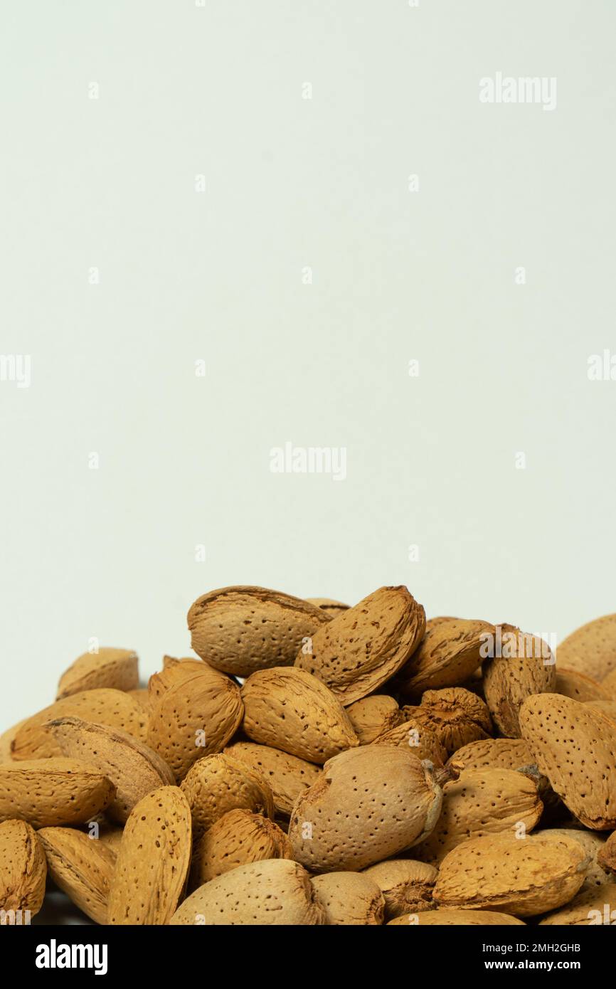 Whole almonds in shell closeup against white background Stock Photo - Alamy