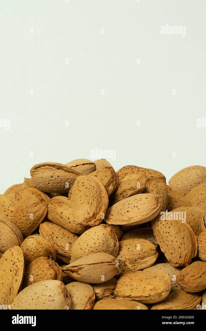 Whole almonds in shell closeup against white background Stock Photo - Alamy