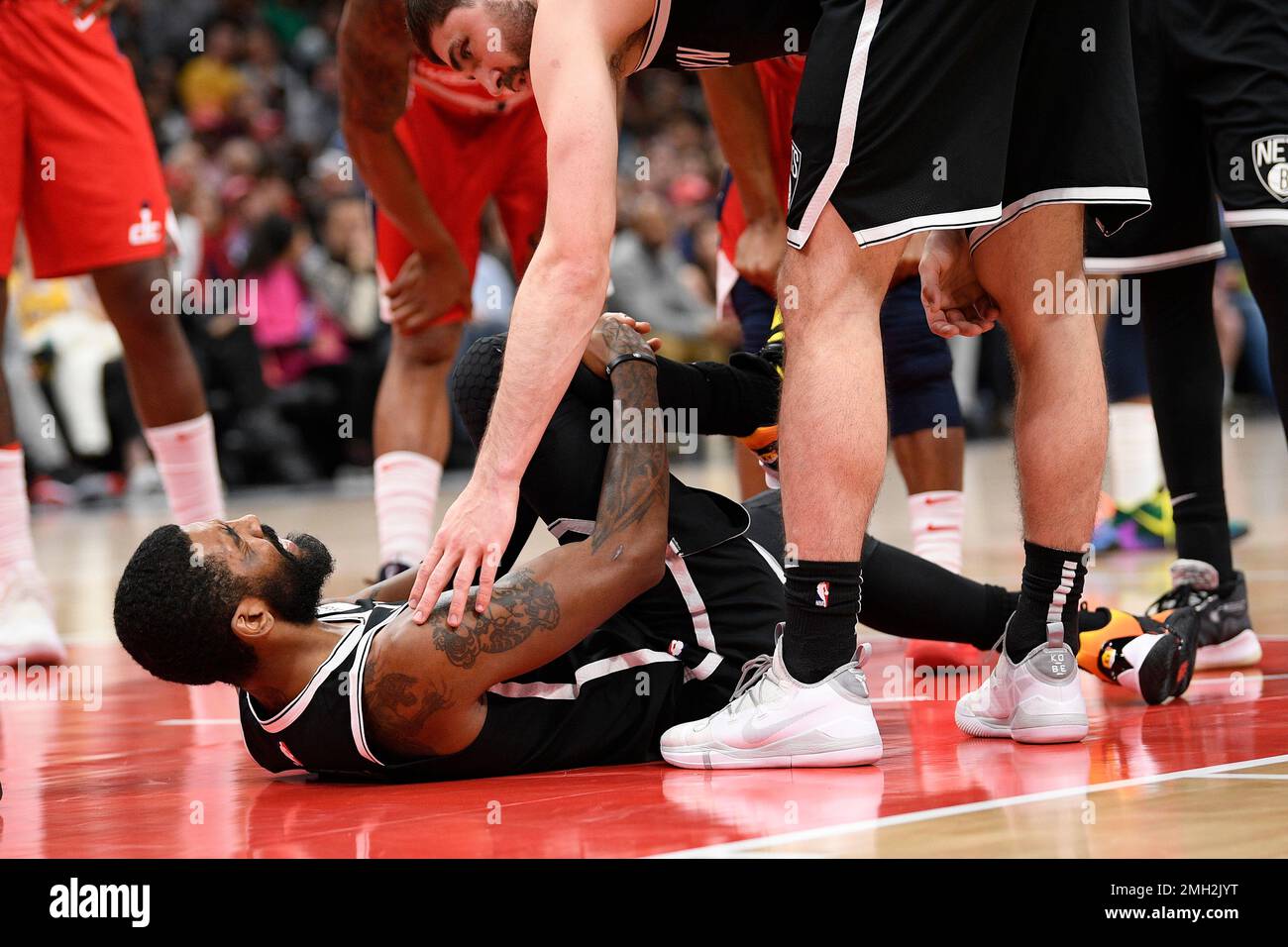 Brooklyn Nets guard Kyrie Irving reacts as he grabs his leg after he ...