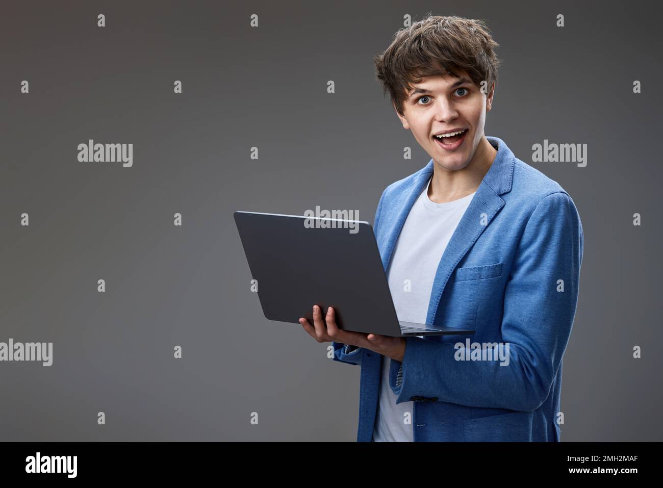 caucasian young man using laptop isolated on gray background Stock ...