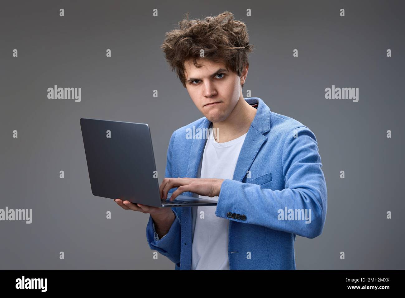 caucasian man with laptop on gray background Stock Photo - Alamy