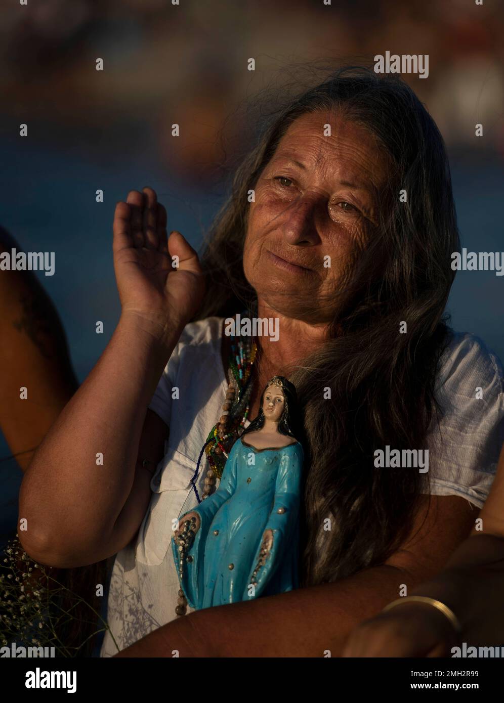 A woman enters the sea with a statue that depicts the African sea ...