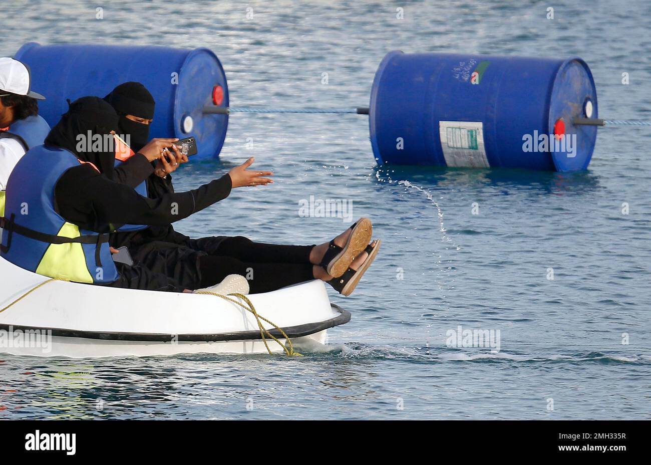 Holiday makers enjoy a swan paddle boat at the beach of the Red Sea ...