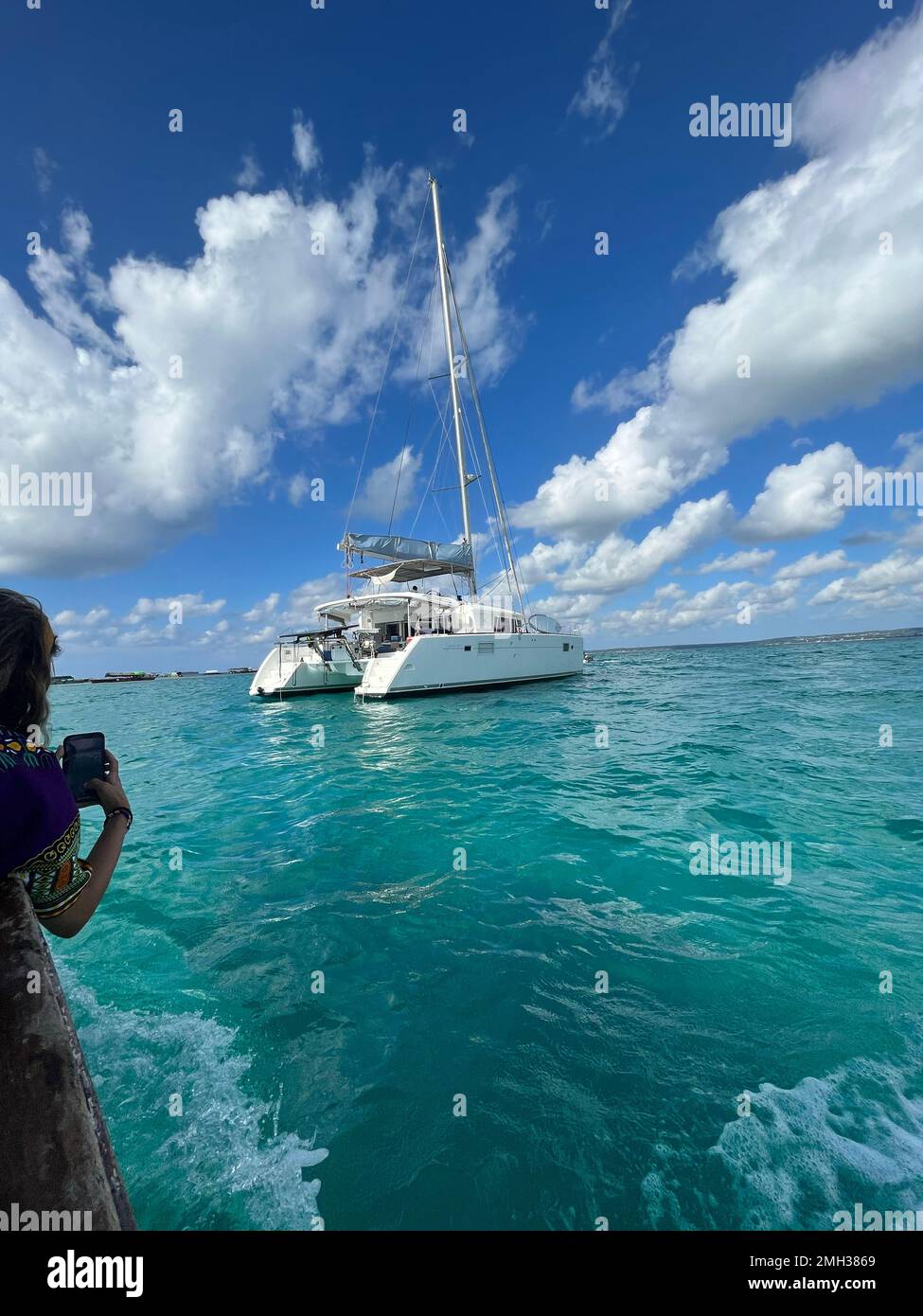 a woman is taking a picture of a one white sailing boat,tourist ...