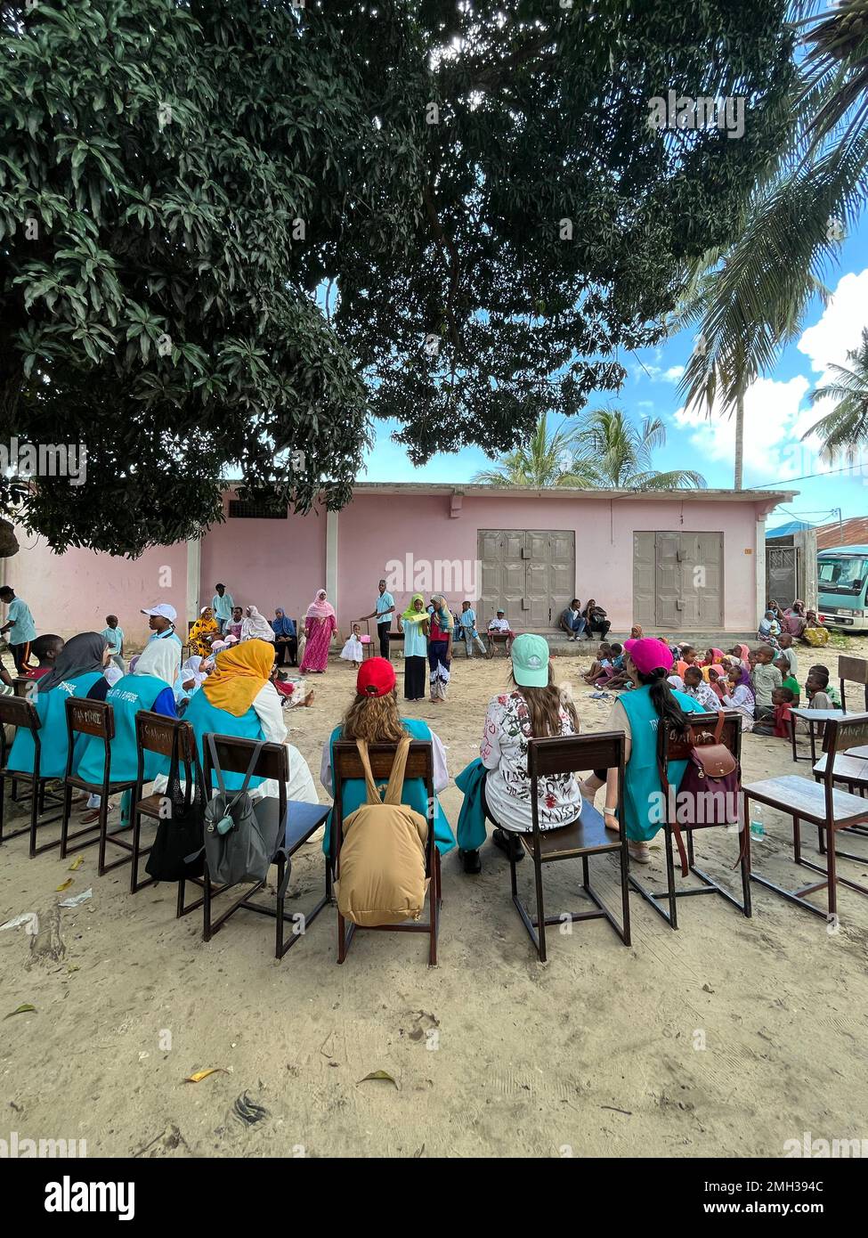 Group of volunteers sitting on a circle in the poor country to help ...