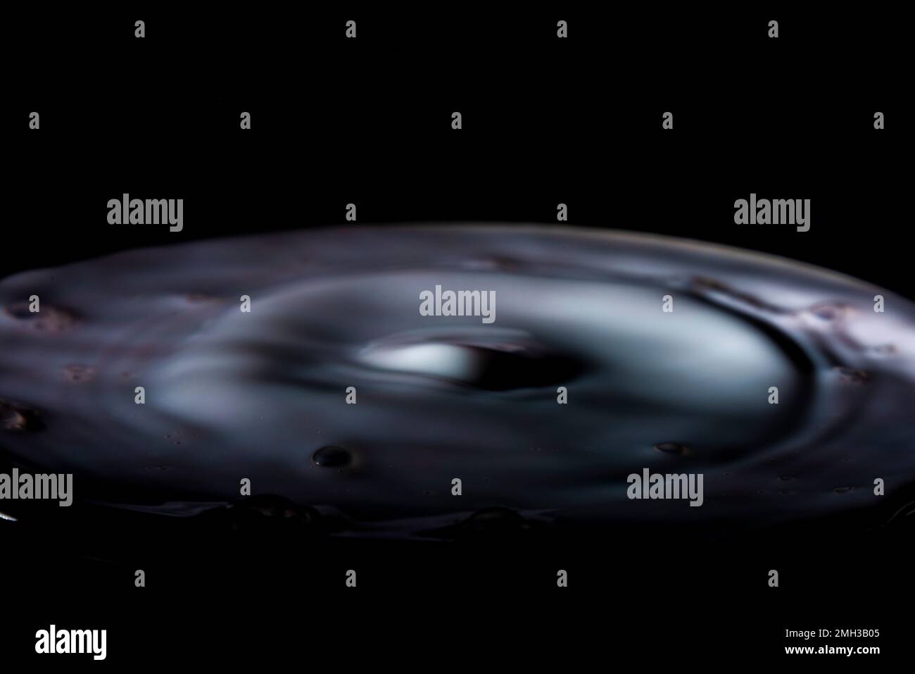 Color fresh sweet milk drops into another color of milk in cup with ...