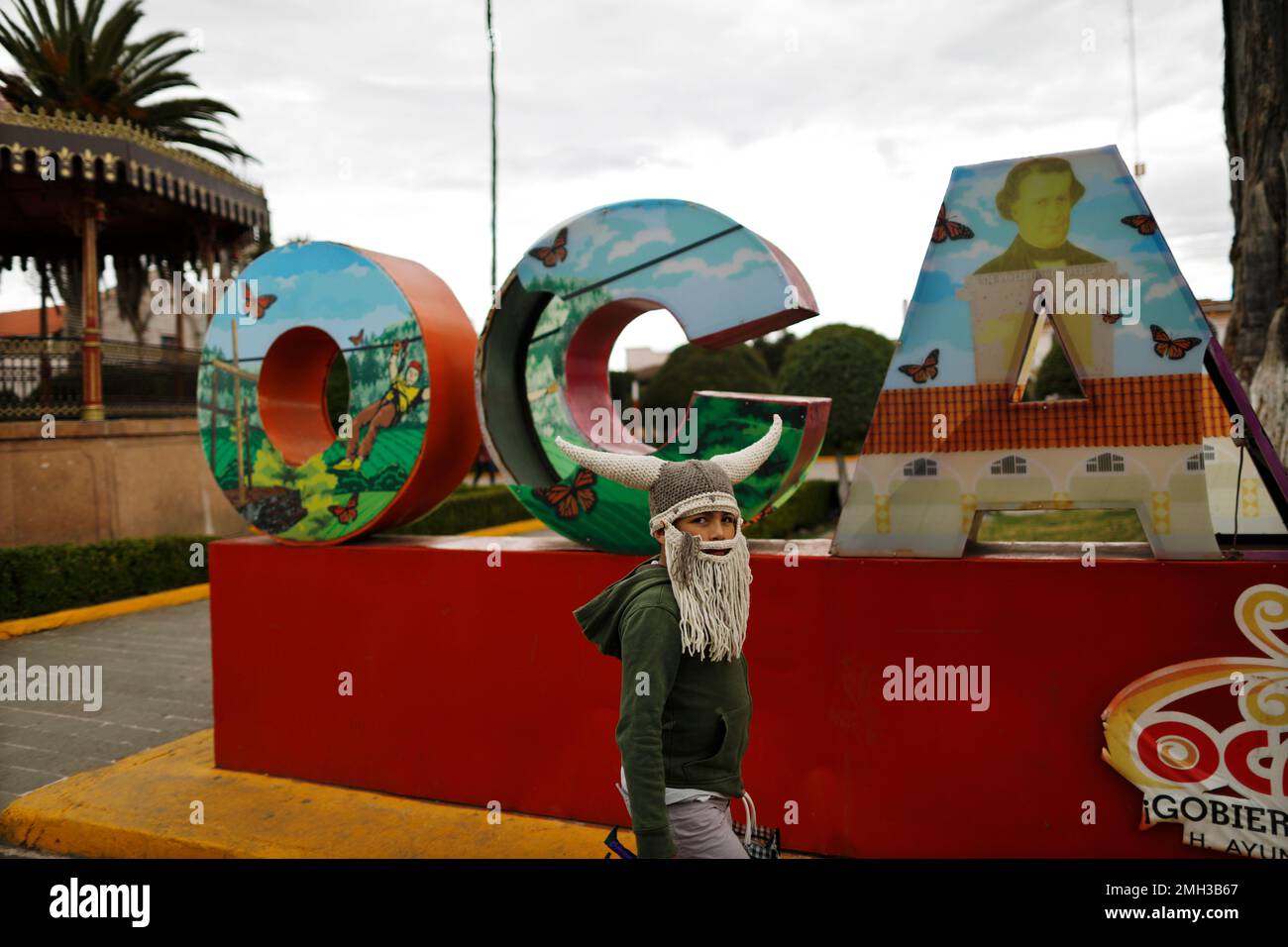A boy walks past giant letters spelling out the town name, in the ...