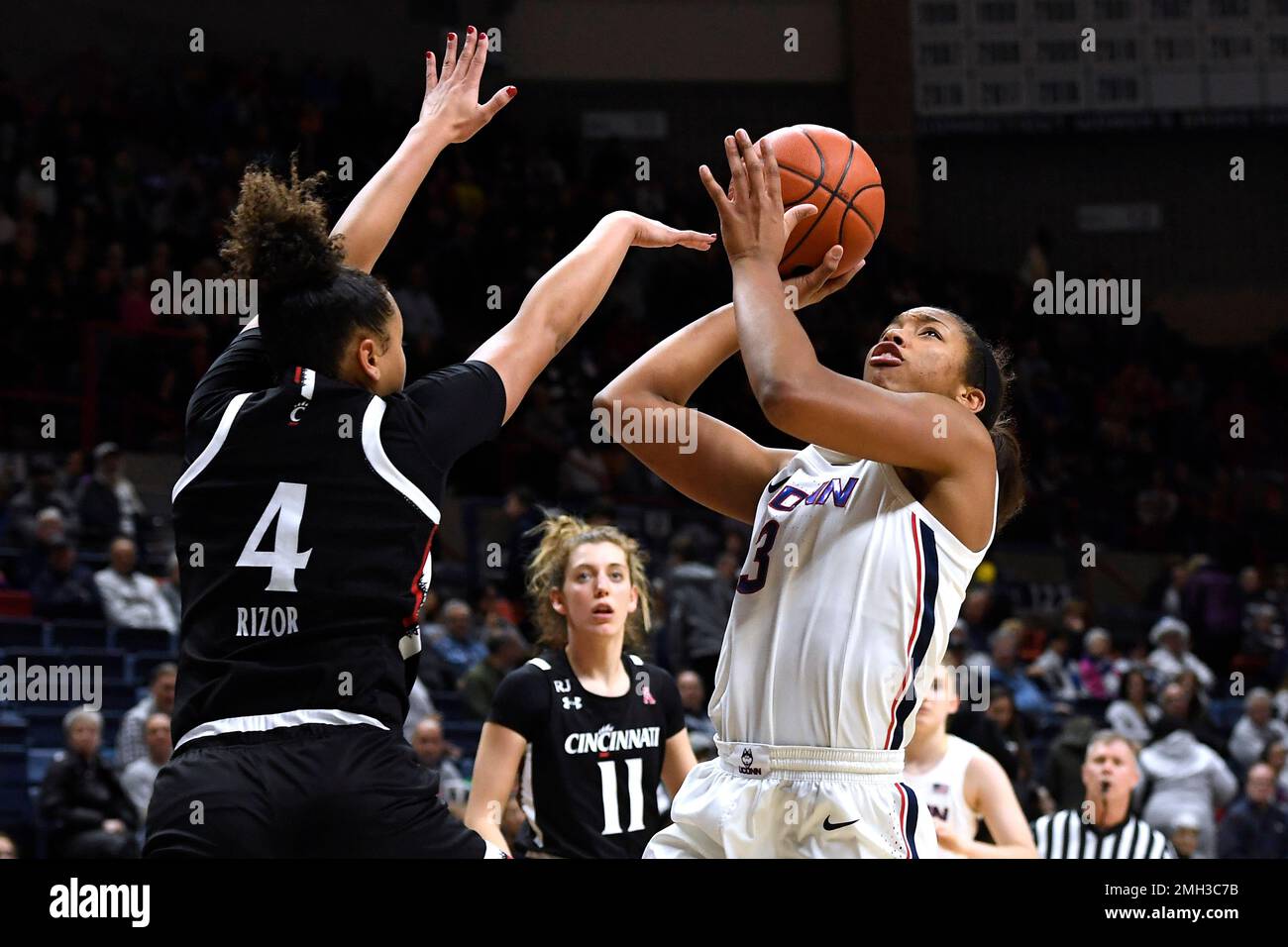 Connecticut's Megan Walker, right, shoots over Cincinnati's Angel Rizor ...
