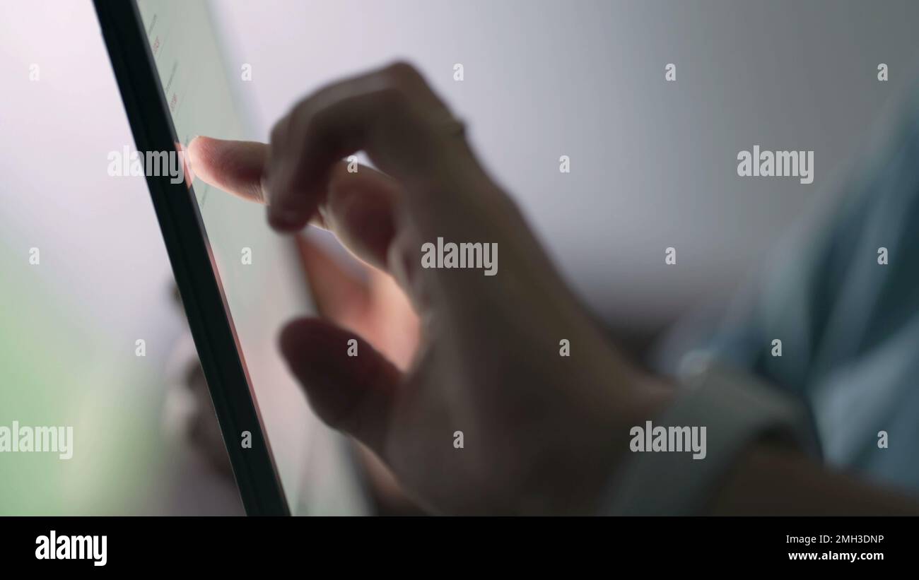 Closeup hand touching tablet screen. Person holding device browsing ...