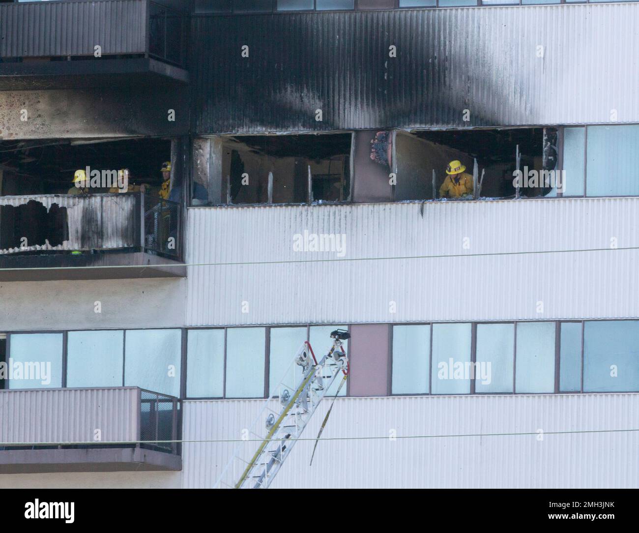 Firefighters stand on the main floors involved on a fire at a ...