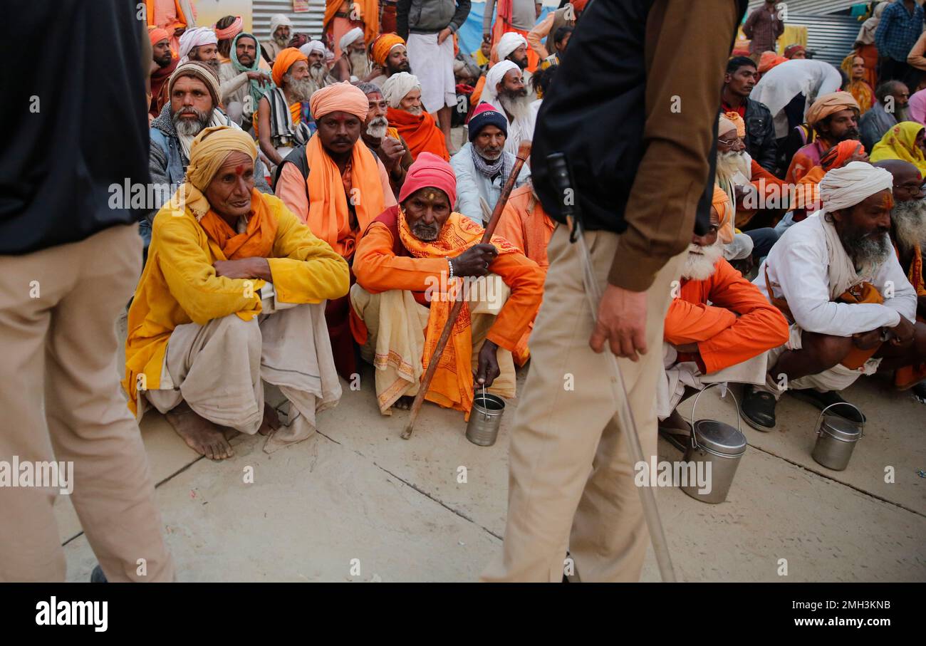 Hindu holy men squat at the Sangam, the confluence of rivers Ganges and ...