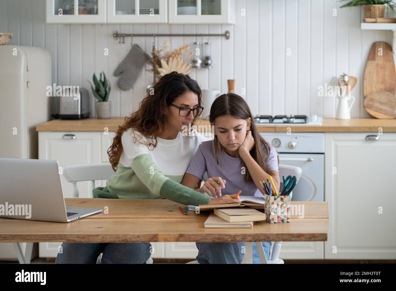 Mother and teen girl daughter studying together at home, mom helping child with homework Stock ...