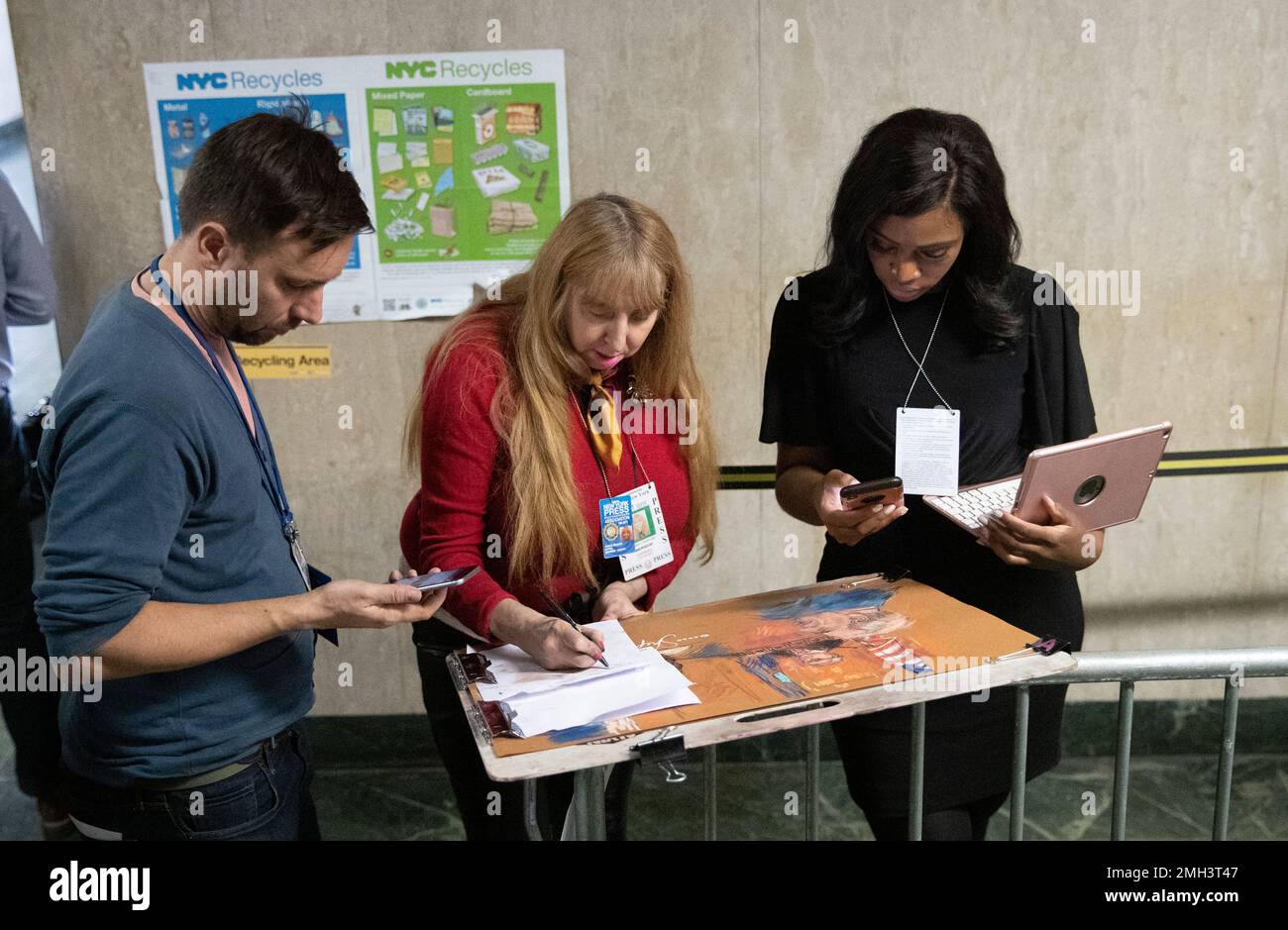 Courtroom artist Andrea Shepard, center, shows her work to two ...
