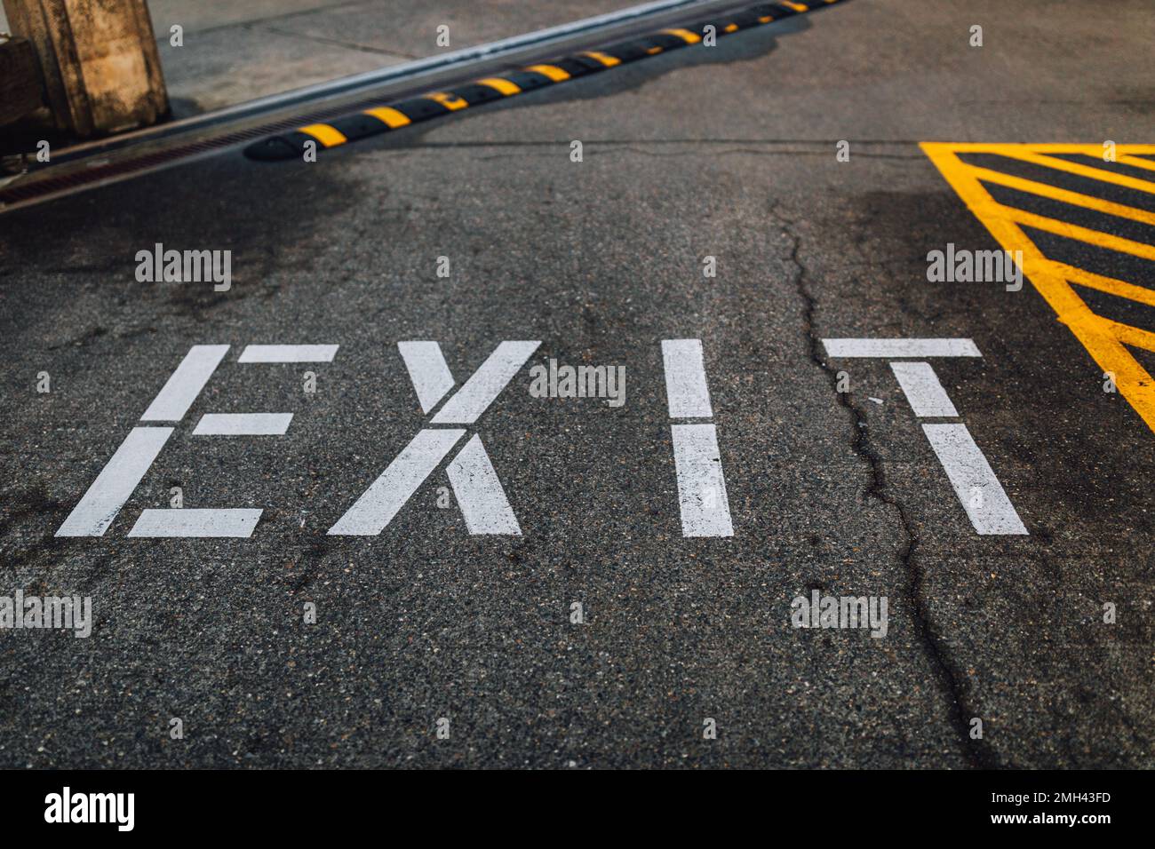 EXIT sign stenciled on concrete ground with white paint Stock Photo - Alamy