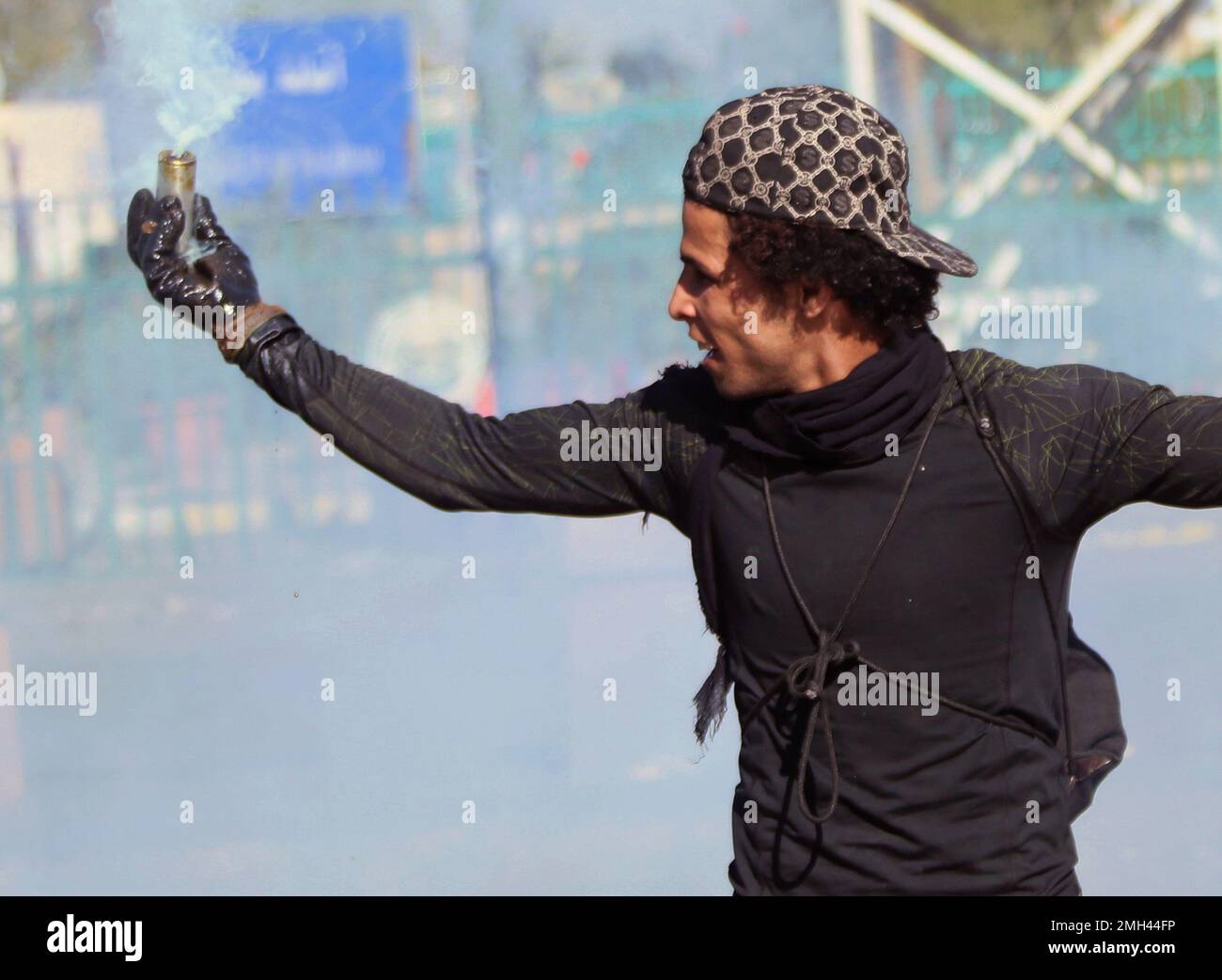 A protester prepares to put a tear gas canister into the water to ...
