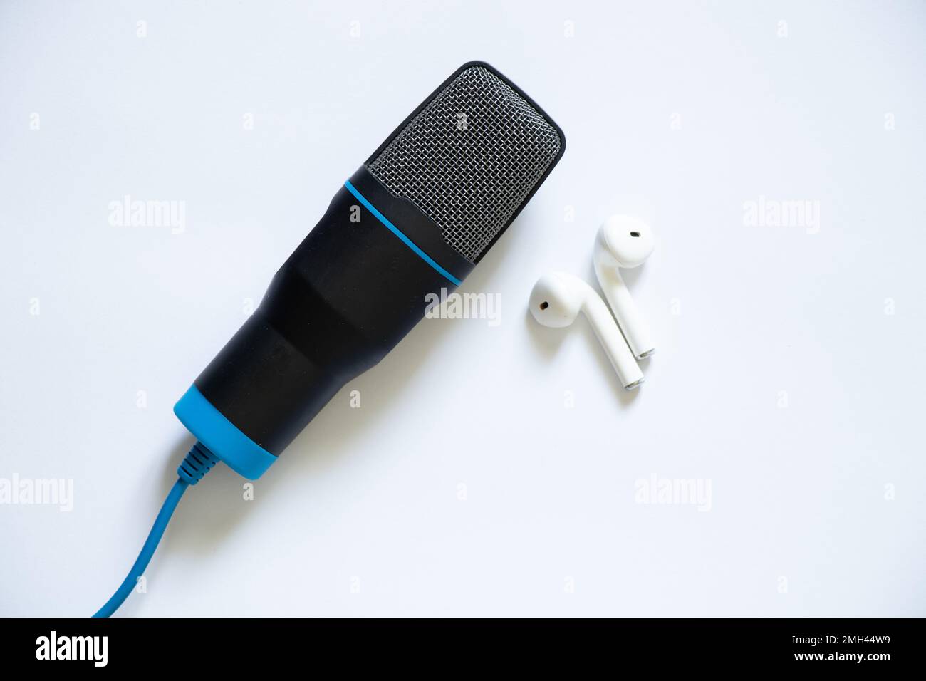 black microphone and white wireless headphones on an isolated ...