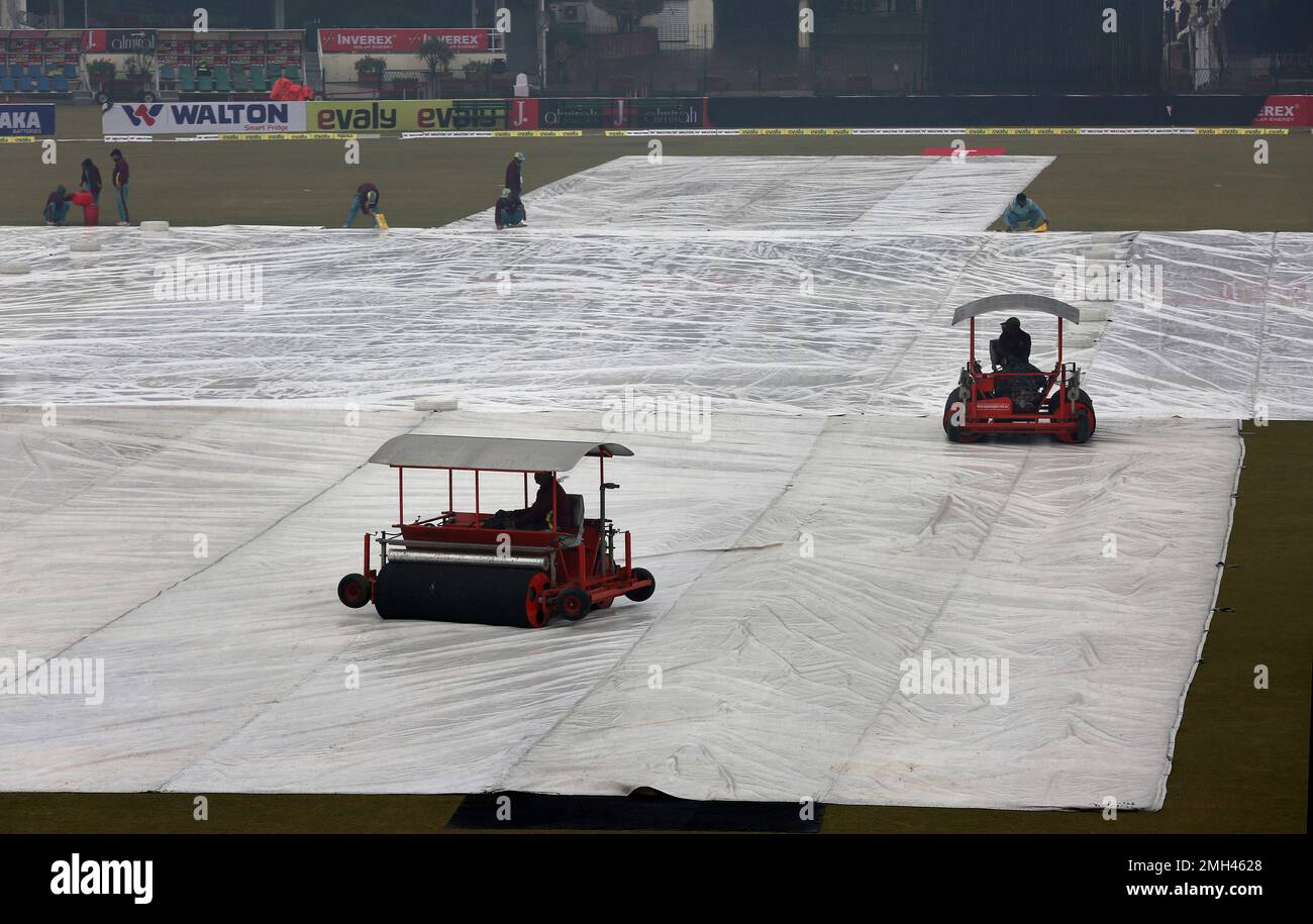 Ground staff work to dry the pitch and field following a light rain at ...