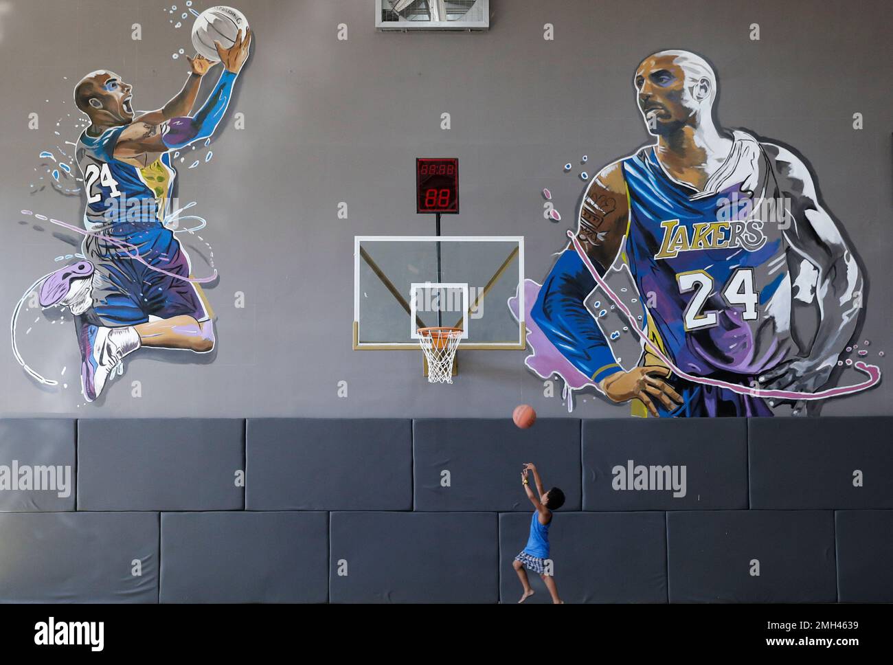 A boy plays in front of images of former NBA basketball player Kobe ...