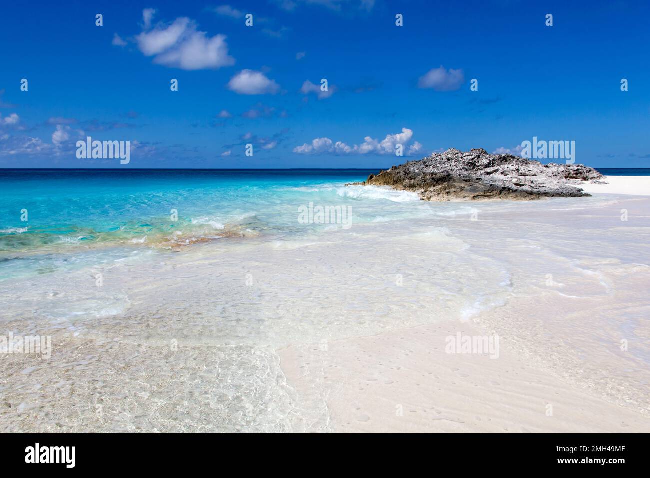 The scenic view of transparent turquoise color waters and a rock in a ...