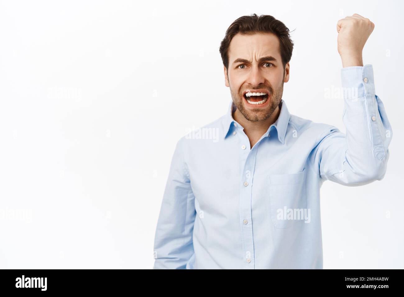Tensed businessman shouting with fist raised up, arguing and screaming ...