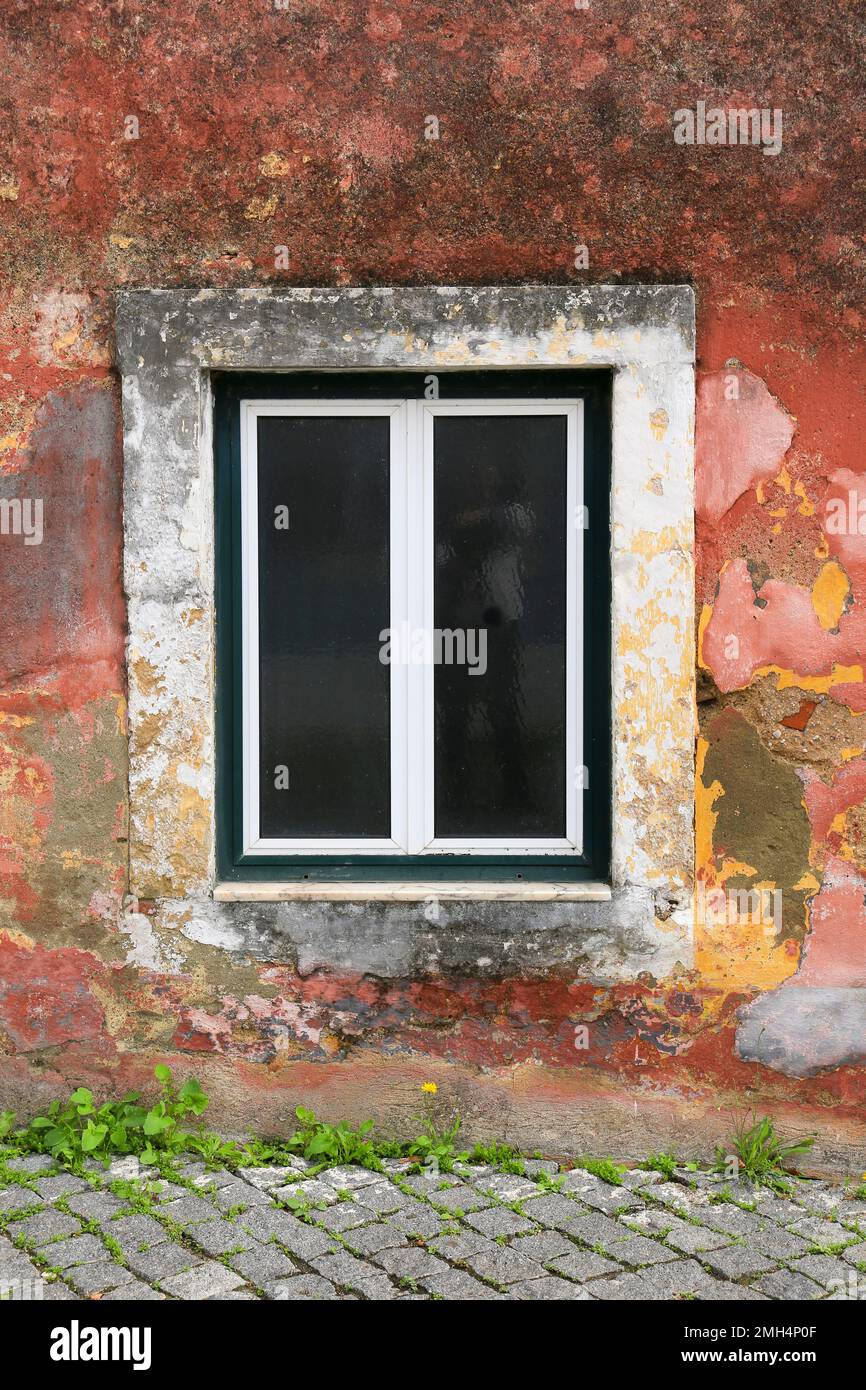 Old house with colorful chipped facade and white metal window in Lisbon ...