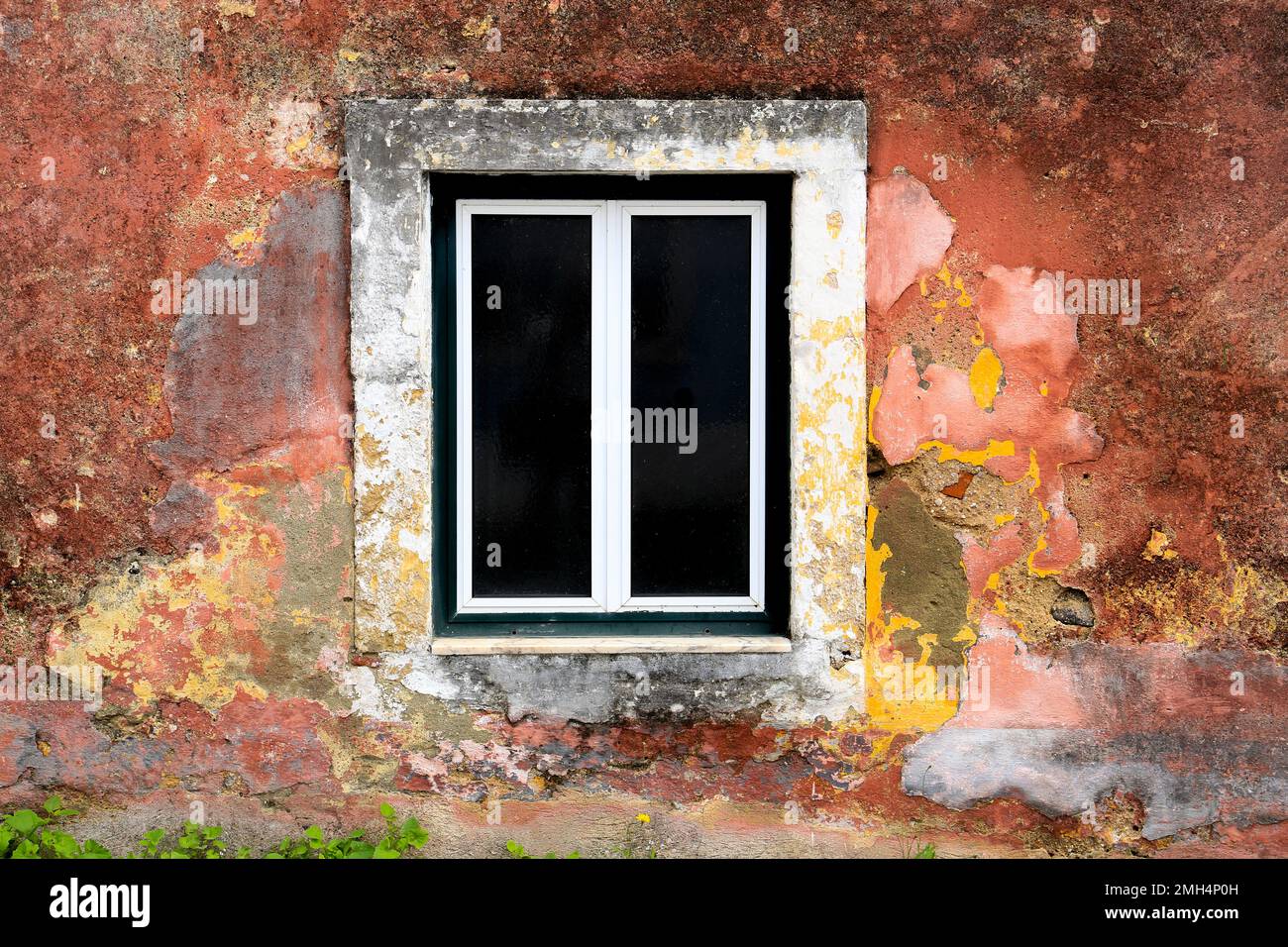Old house with colorful chipped facade and white metal window in Lisbon ...
