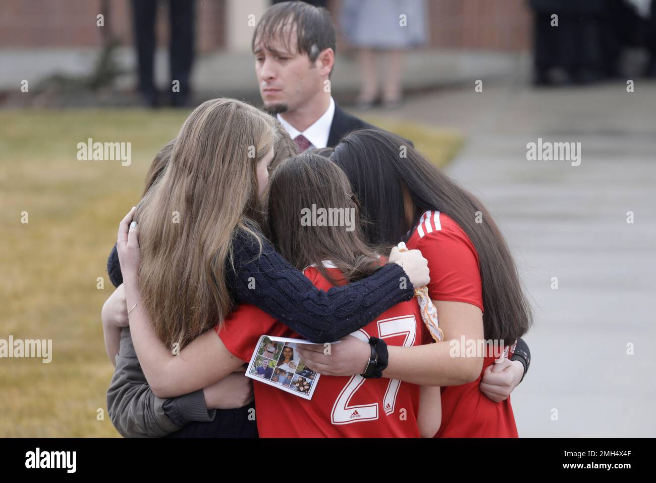 Mourners embrace following funeral services to remember a mother and ...