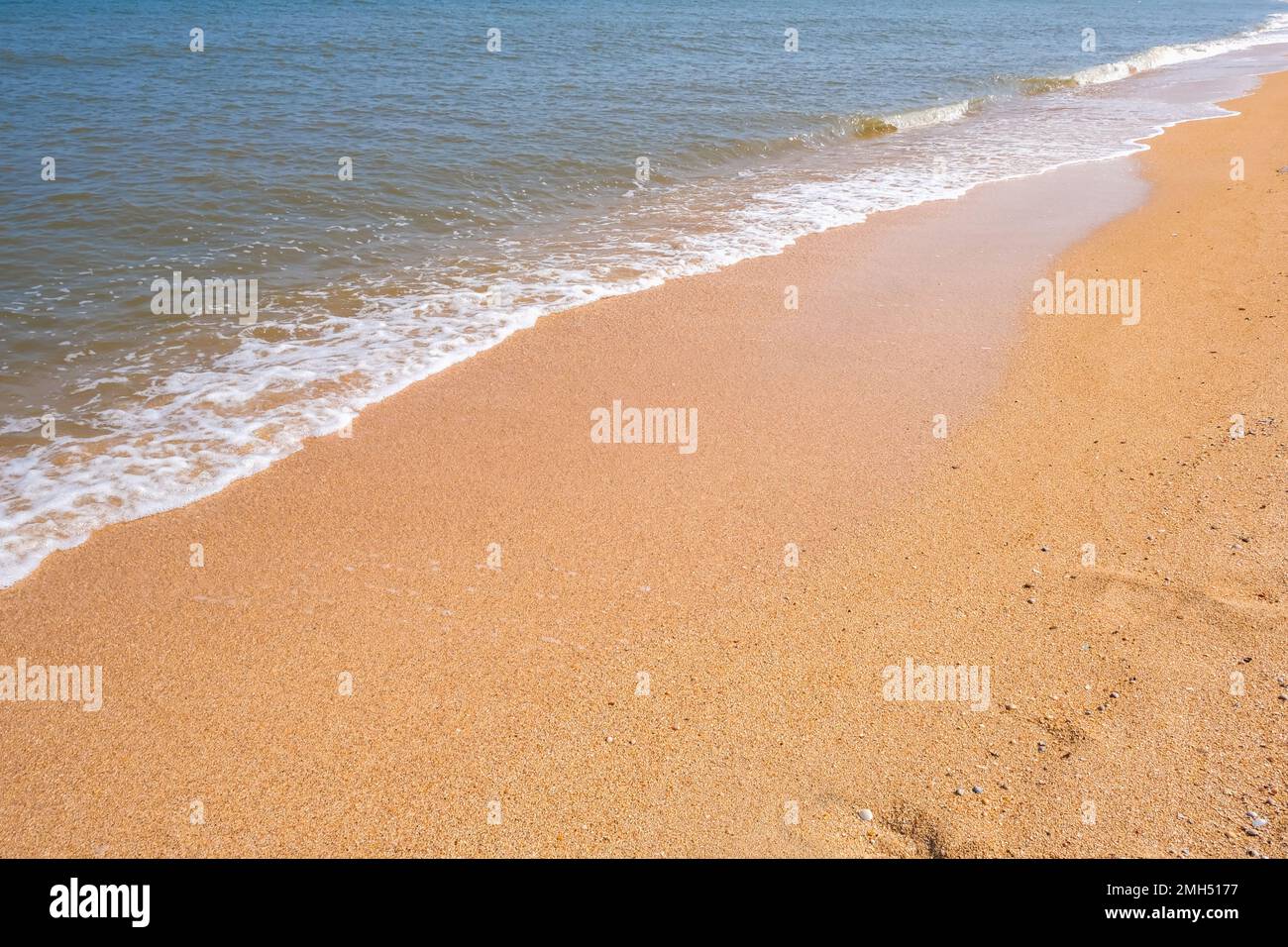 The coast of the Sea of Azov. Sea waves roll on the sandy shore ...