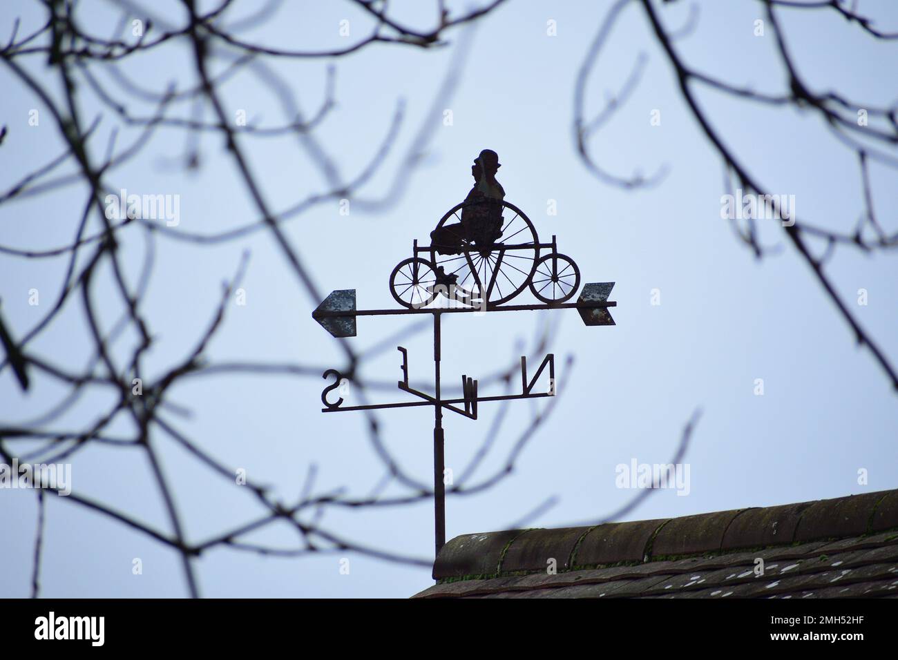 Weathervane of a man on a tricycle Stock Photo - Alamy