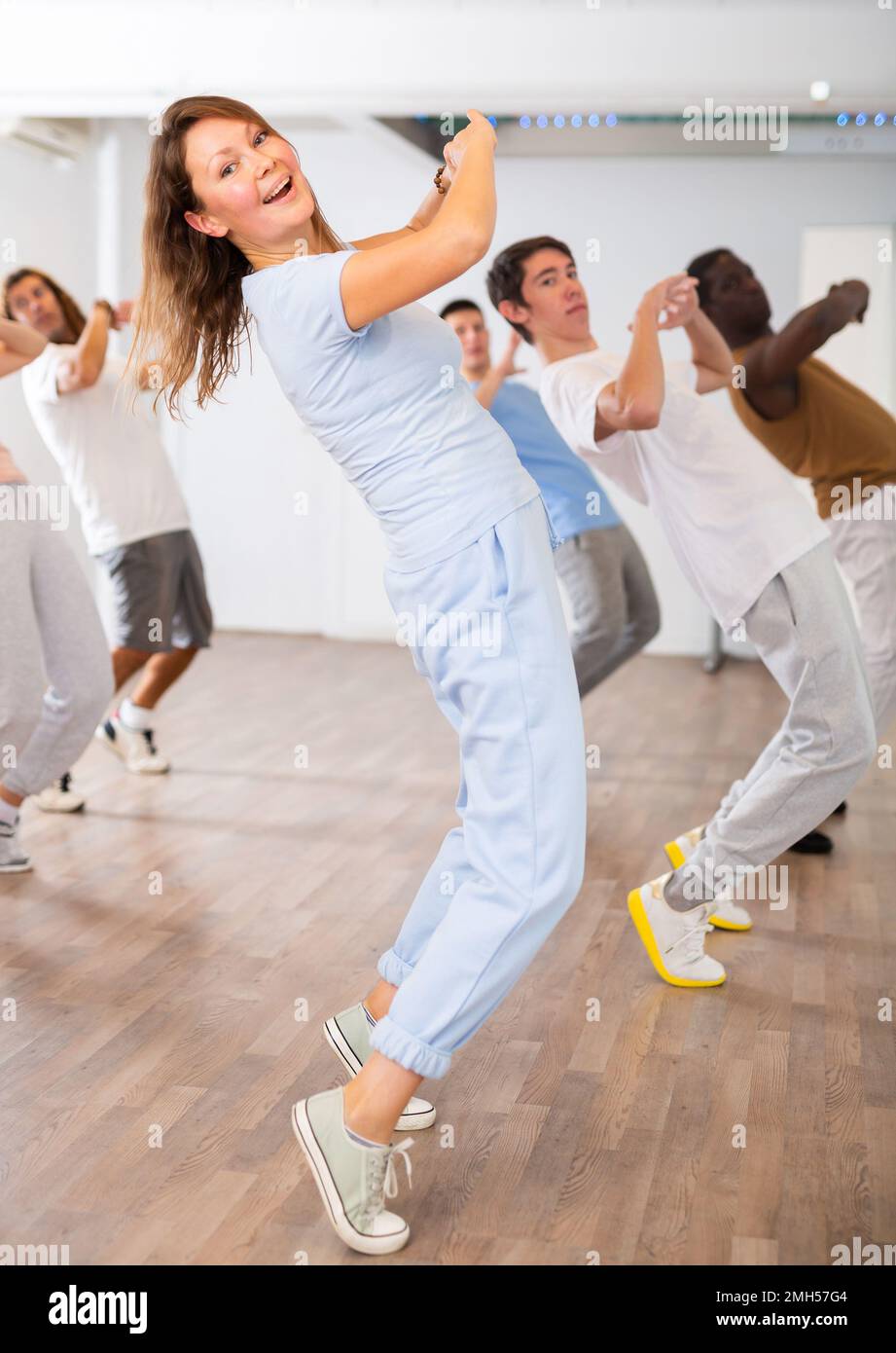 Group of positive young adult active multiethnic dancers leaning back ...