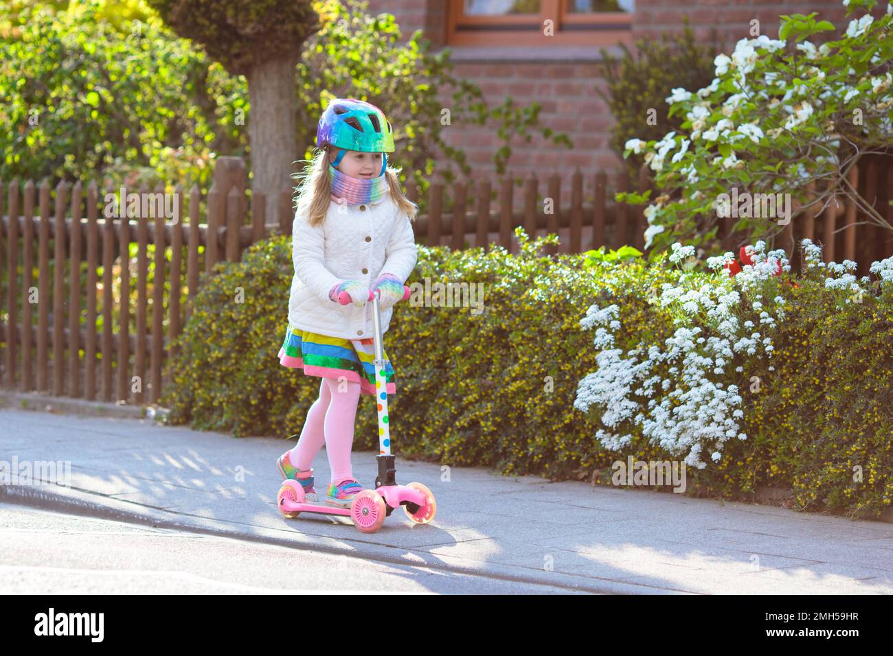 Child riding scooter on way back to school. Little girl playing ...