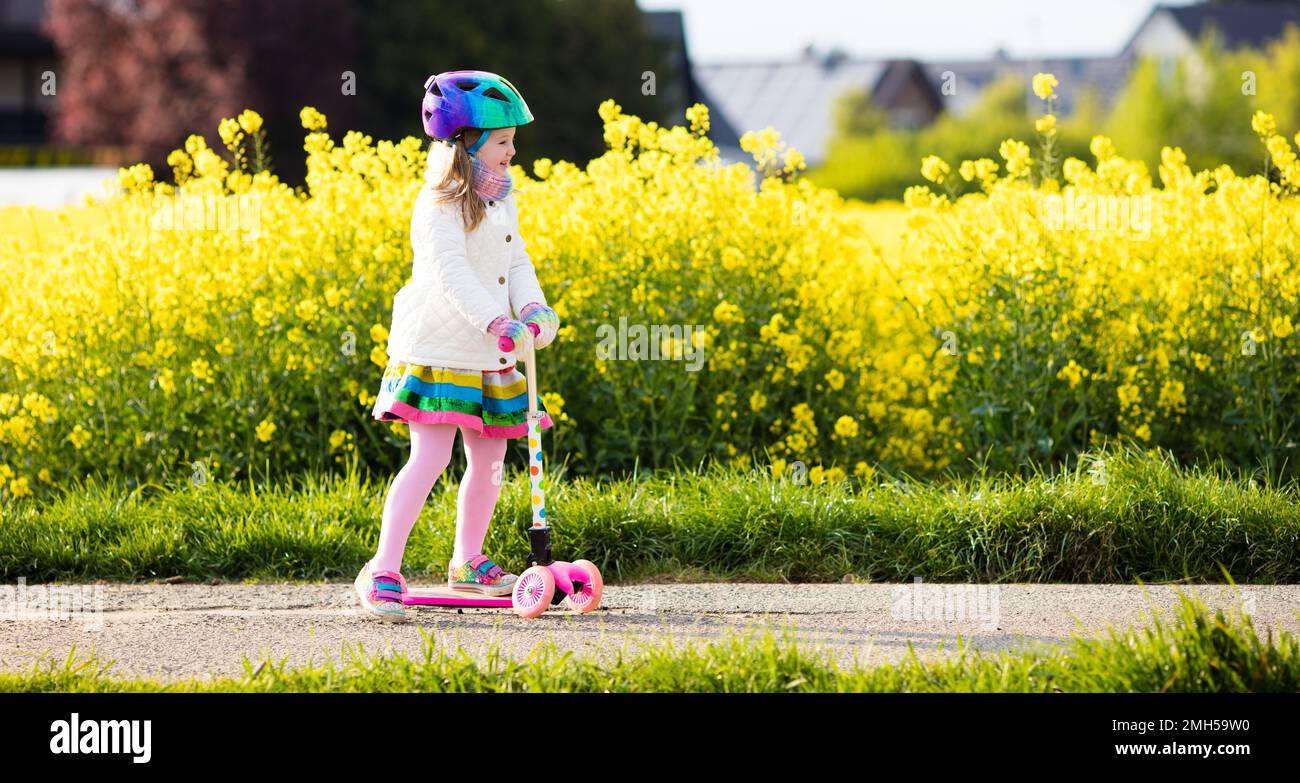 Child riding scooter on way back to school. Little girl playing ...