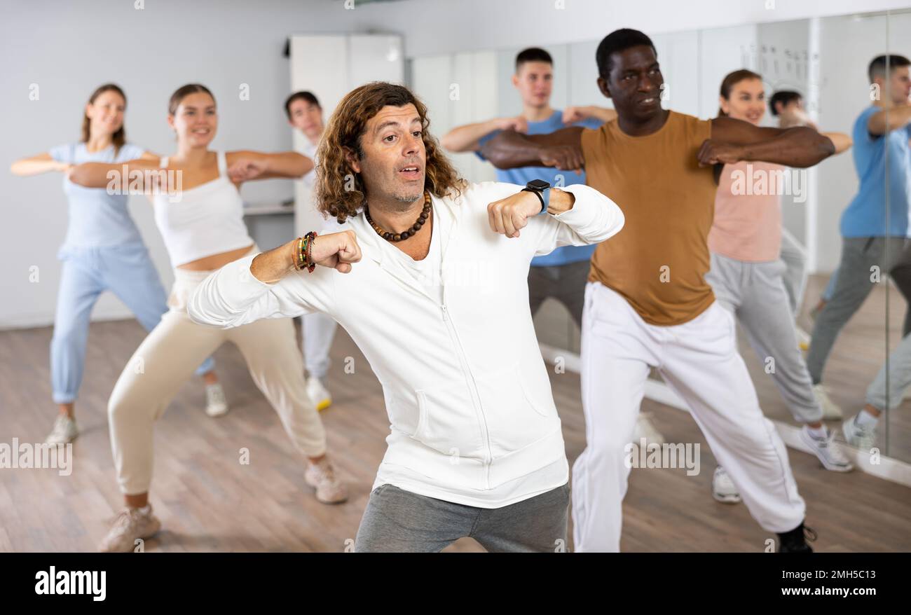 Group of different people rehearsing dance in dance studio Stock Photo ...