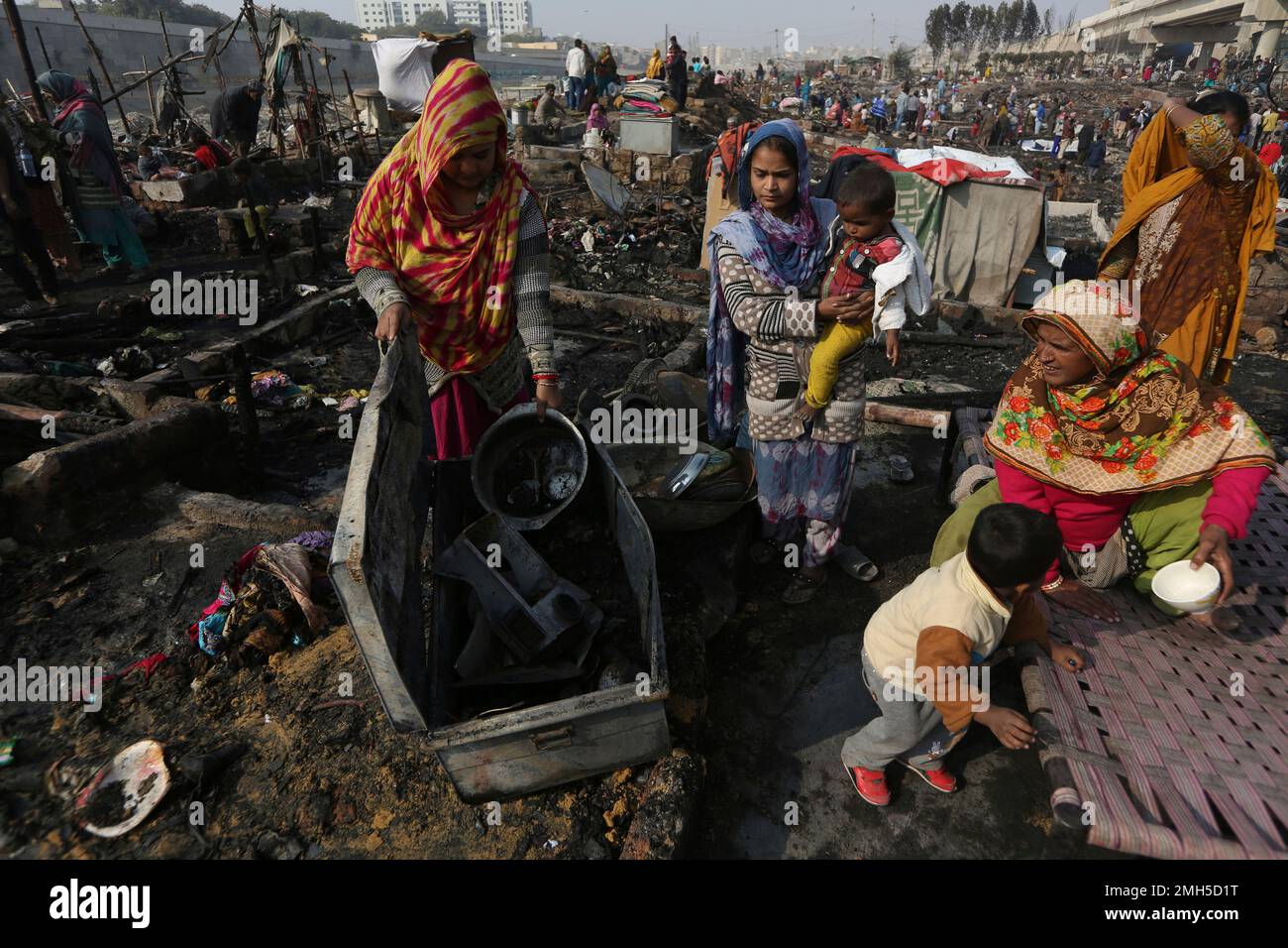 Dwellers collect their belongings after a fire gutted their homes in ...