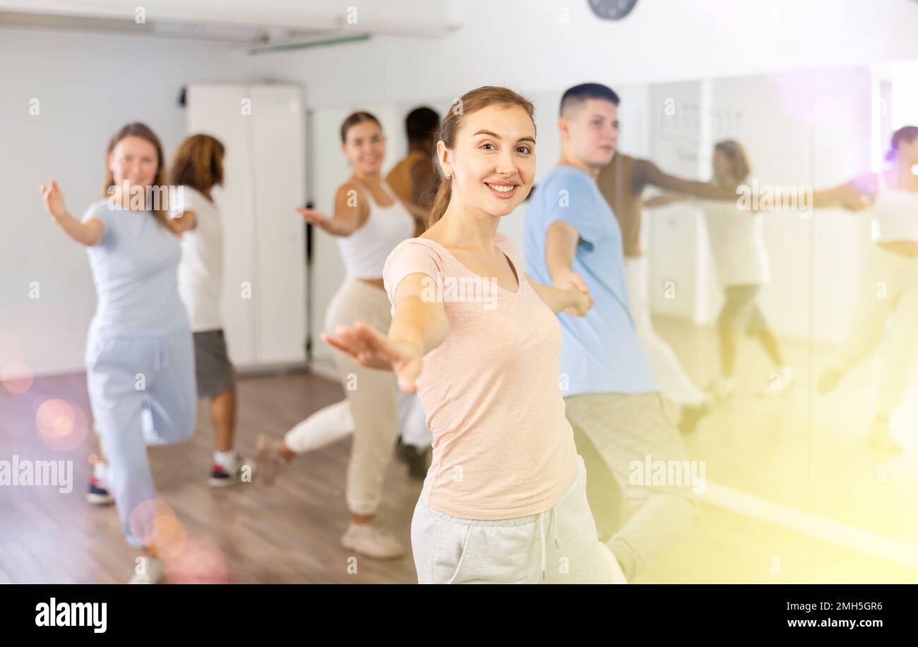 Group of positive smiling young adult people dancing in pairs during ...
