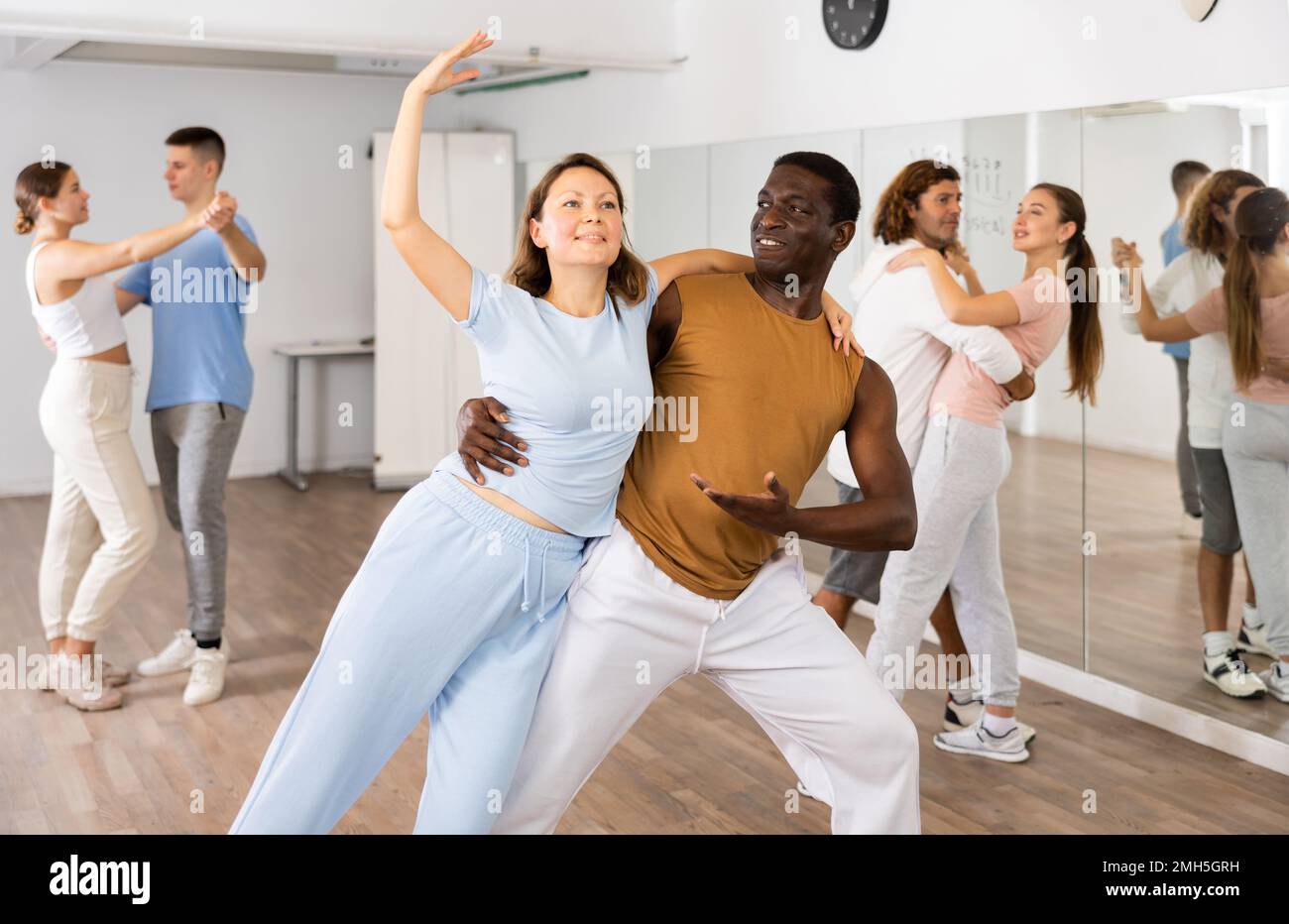 Group of excited young adult people dancing dynamic moves in pairs ...