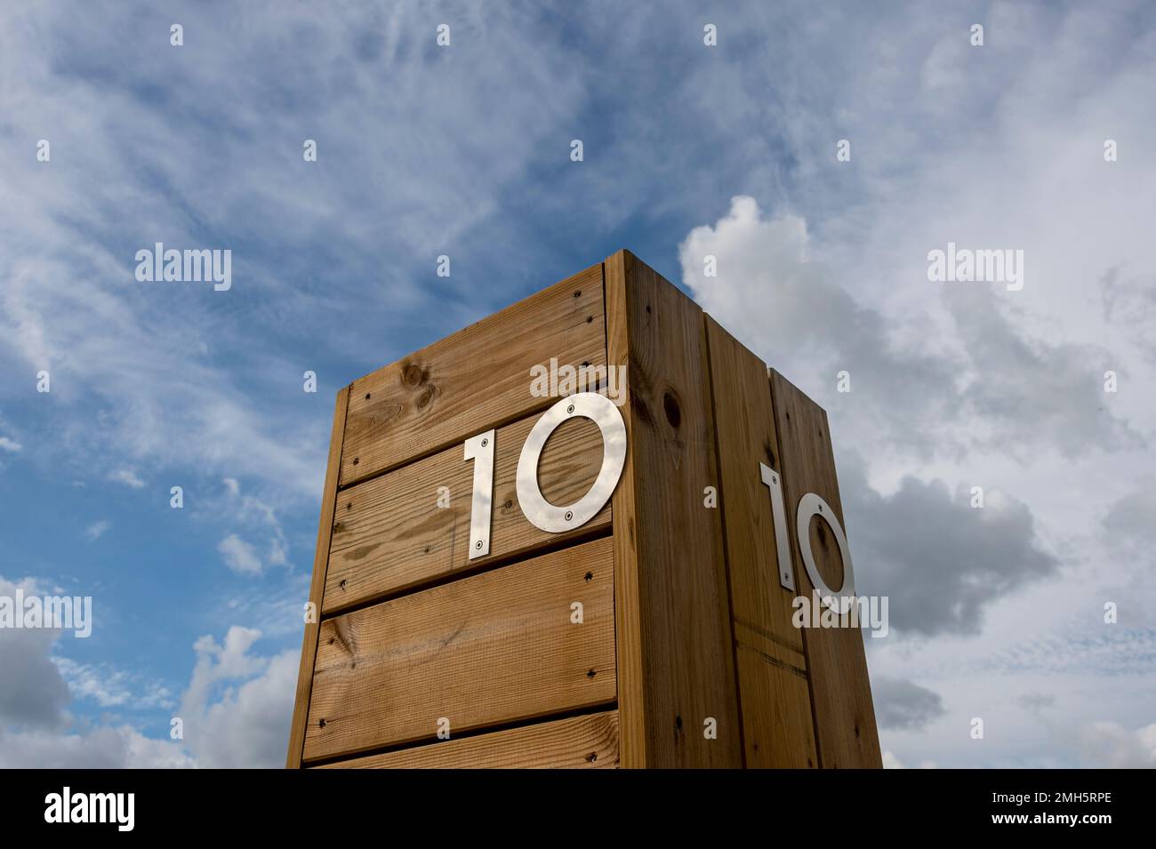 The number ten in stainless steel on a wooden background against the ...