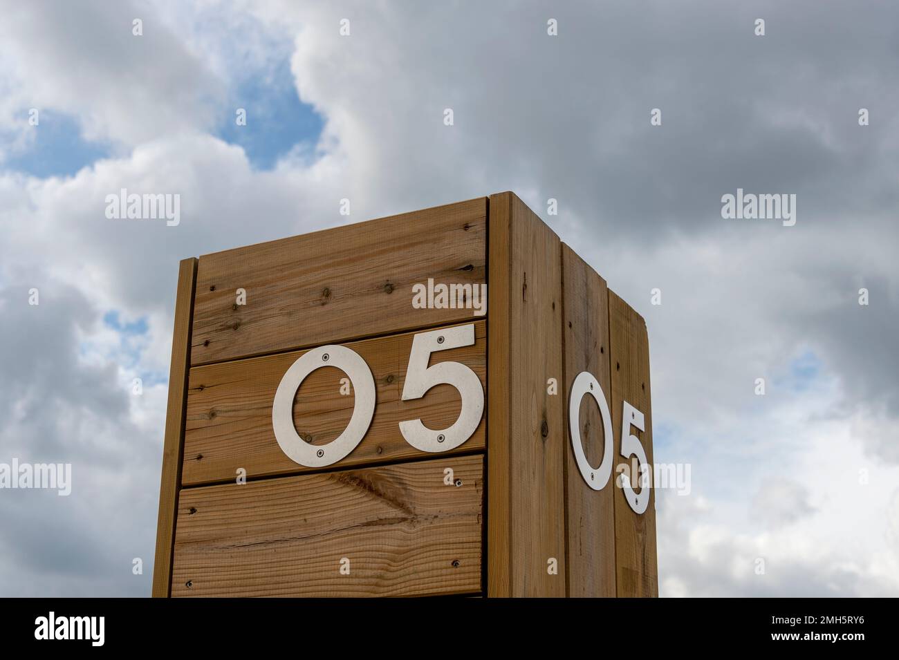 The number five in stainless steel on a wooden background against the ...