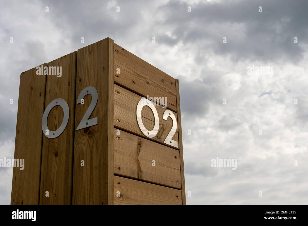 The number two in stainless steel on a wooden background against the ...