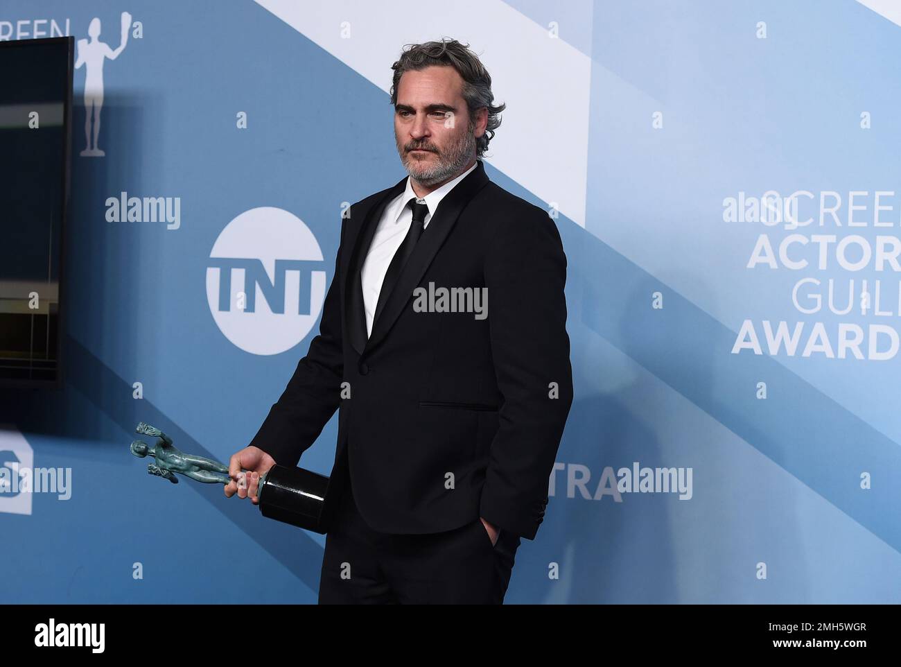 Joaquin Phoenix poses in the press room with the award for outstanding ...