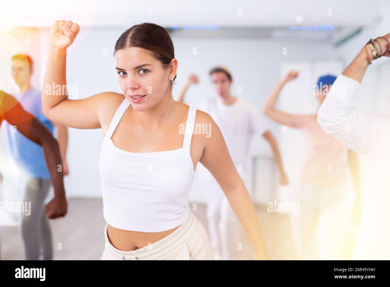 Happy flexible multiethnic men and women exercising active moves with ...