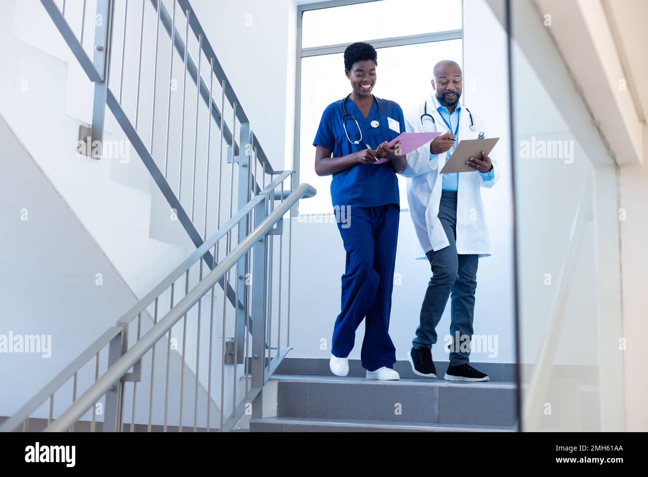 Happy african american female and male doctor talking on hospital ...
