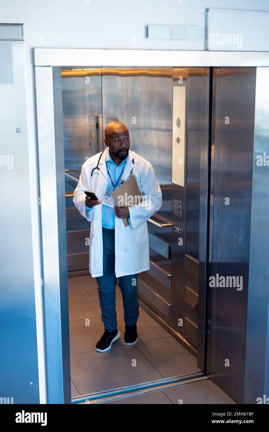 Vertical of african american male doctor using smartphone in hospital ...