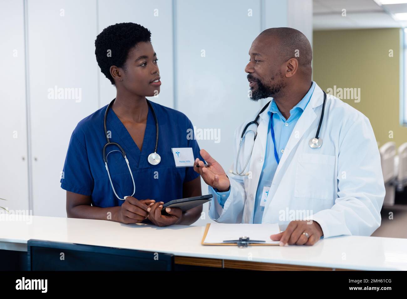 African american male and female doctor talking in hospital corridor ...