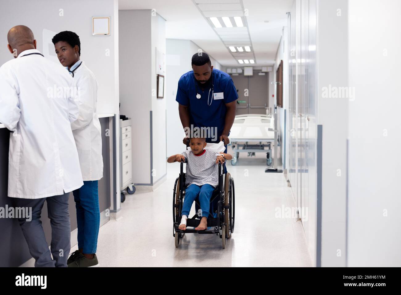 Vertical of african american male doctor pushing boy patient in ...
