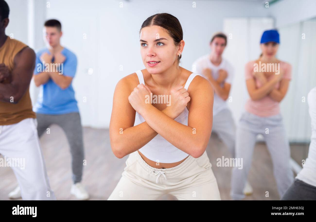 Group of young adult diverse active dancers in sportswear with crossed ...